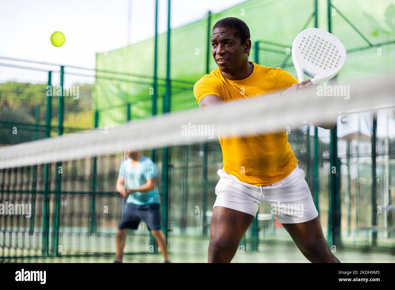 Male players playing padel in a padel court outdoor behind net Stock ...