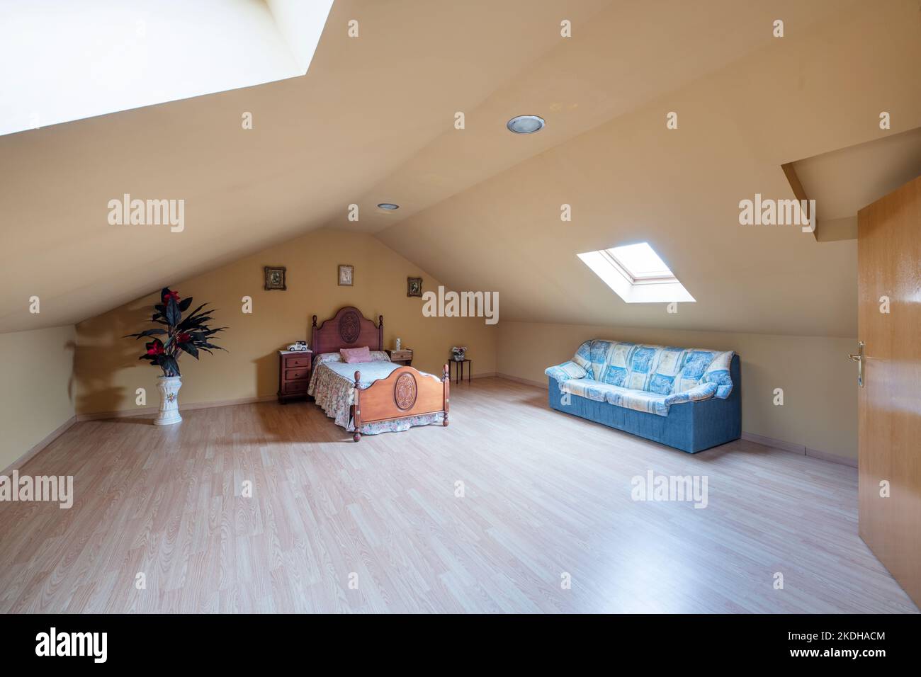 Room in the attic of a single-family house with a small wooden bed and ...