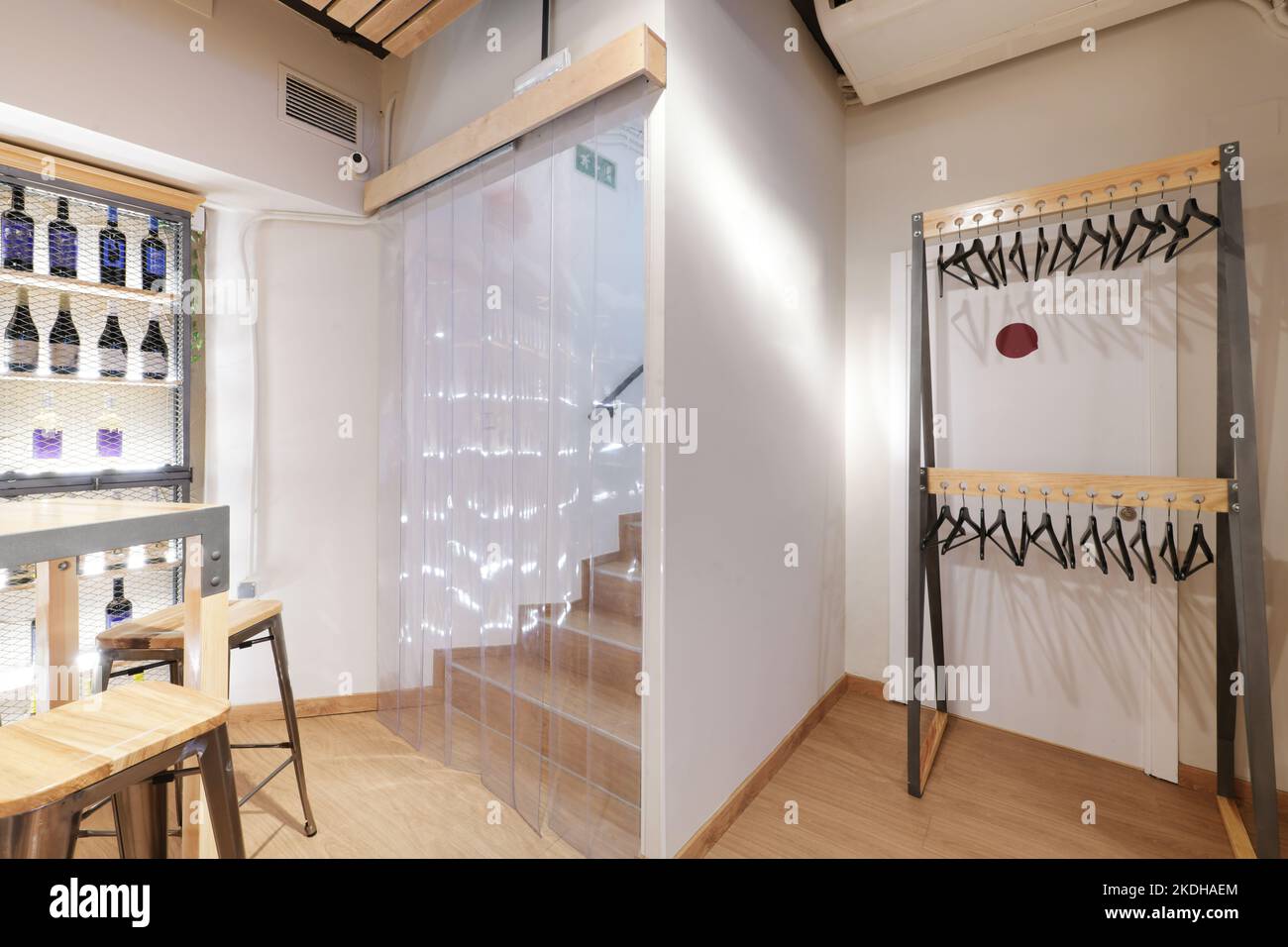 Room with a double rack with hangers to hang clothes and stairs to ...