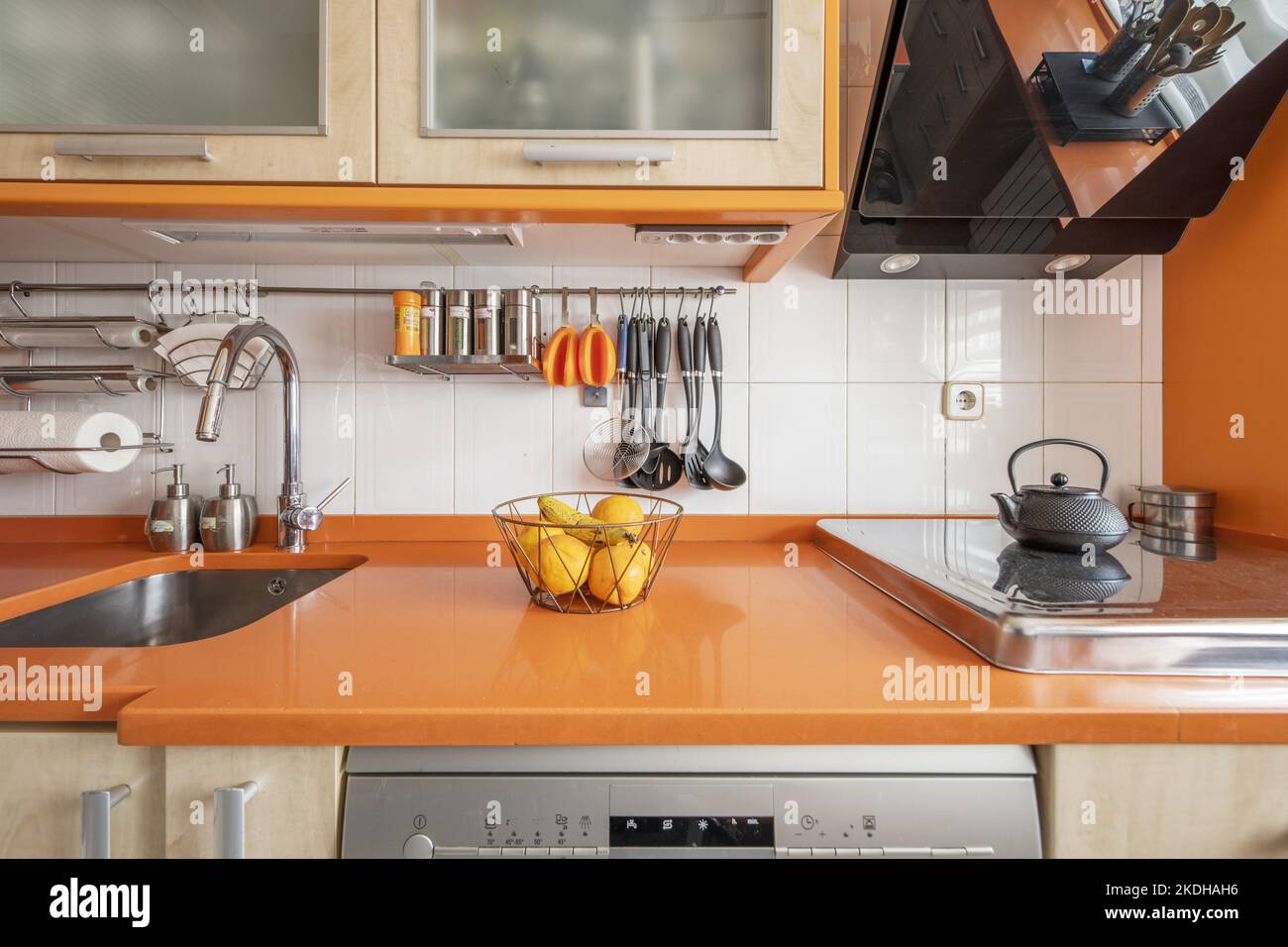 Kitchen with cream wood cabinets paired with orange countertops and ...