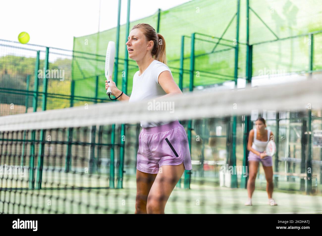 Female player playing padel in a padel court outdoor behind net Stock ...