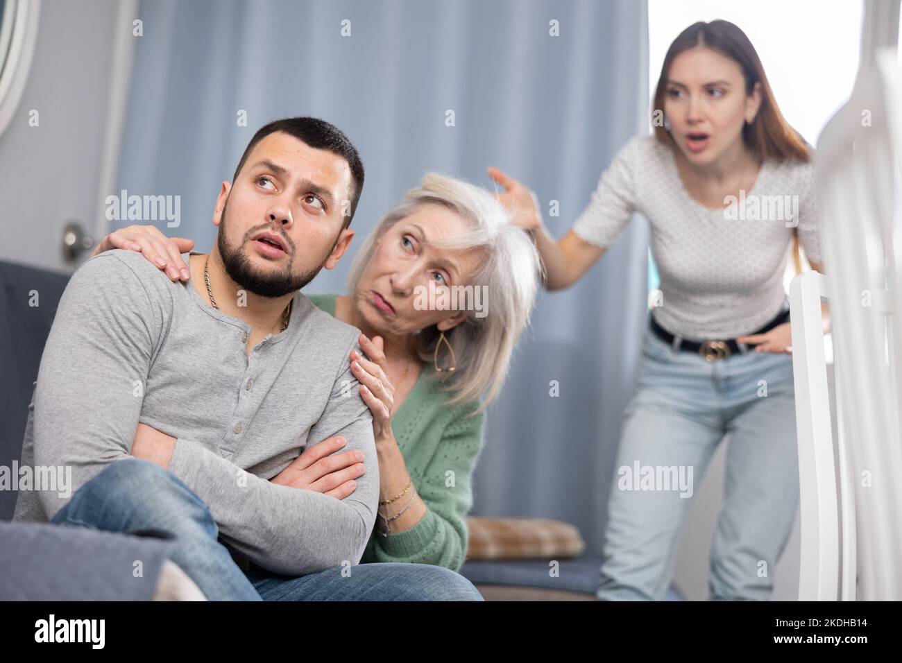 Old woman consoling his adult son during conflict with his wife Stock ...