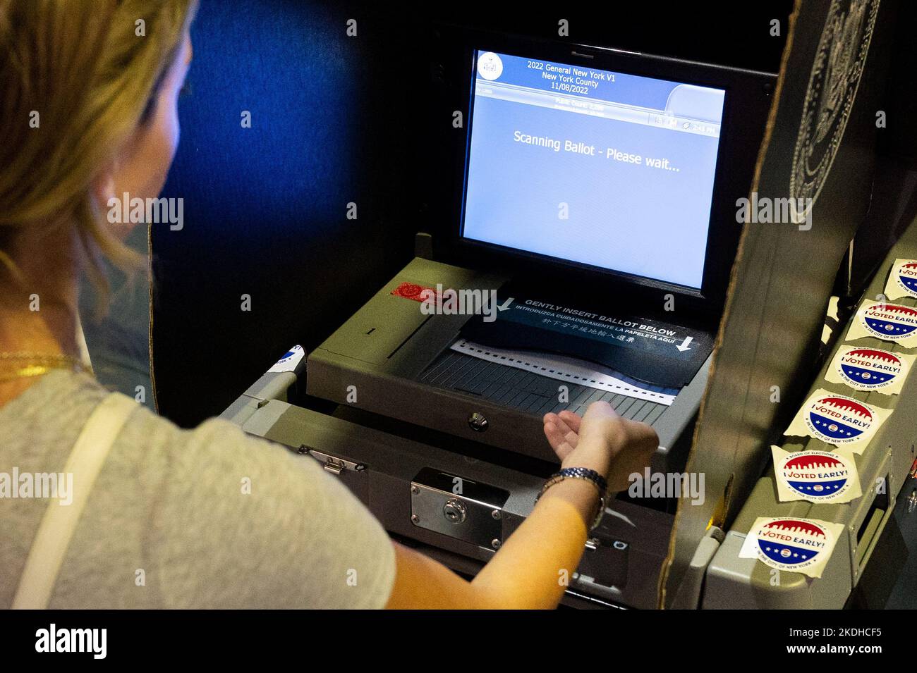 A voter entering their ballot into a scanner at West Side High School ...