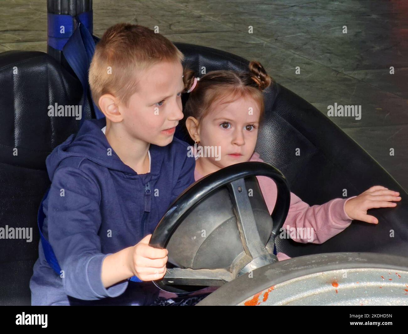 Kid boy pushing and driving car with little toddler girl, cute sister ...