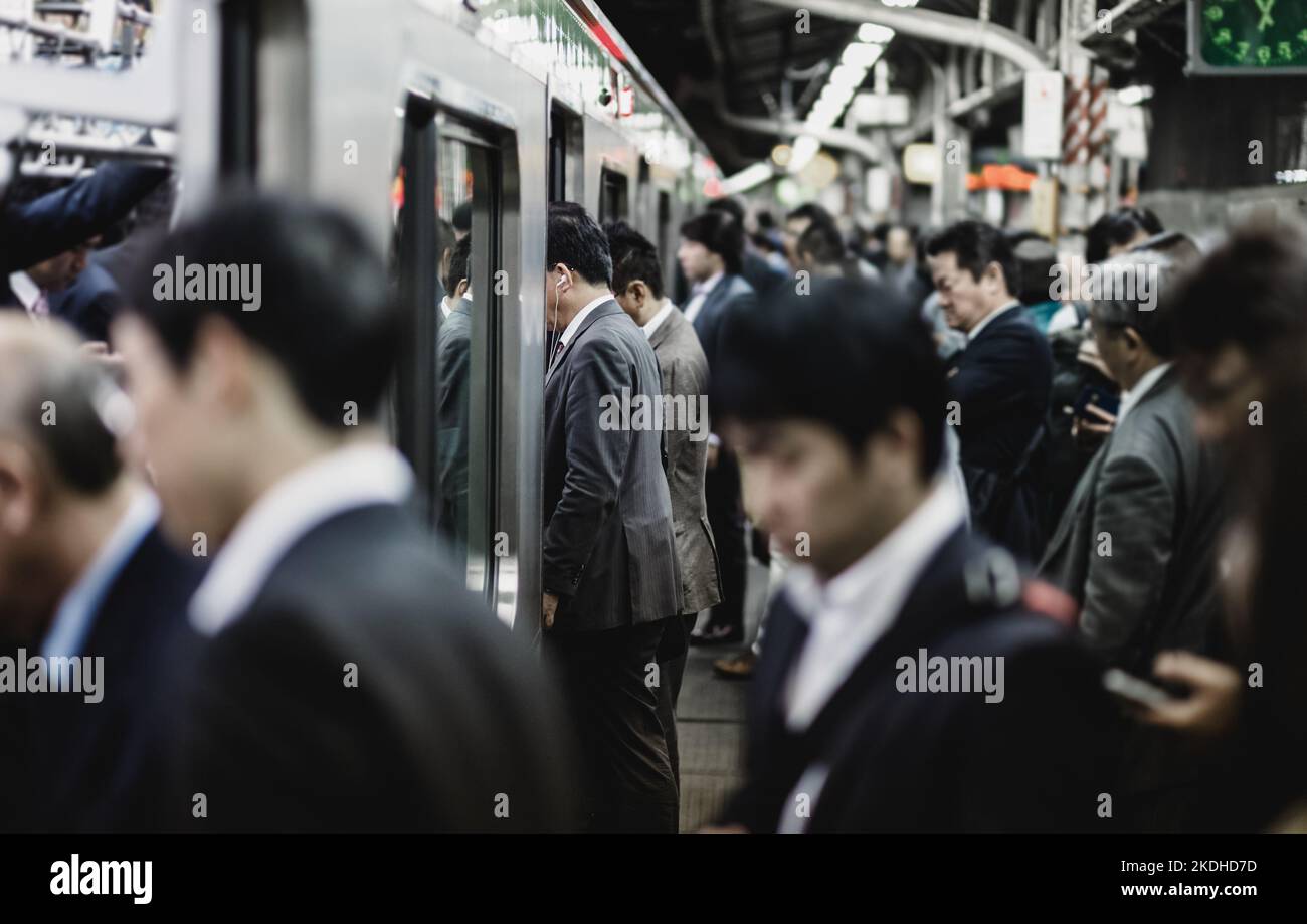 Passengers traveling by Tokyo metro. Business people commuting to work ...