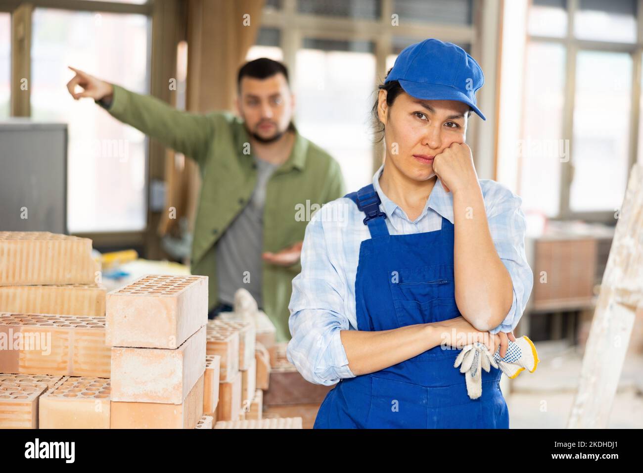 Frustrated female contractor in building under renovation with ...
