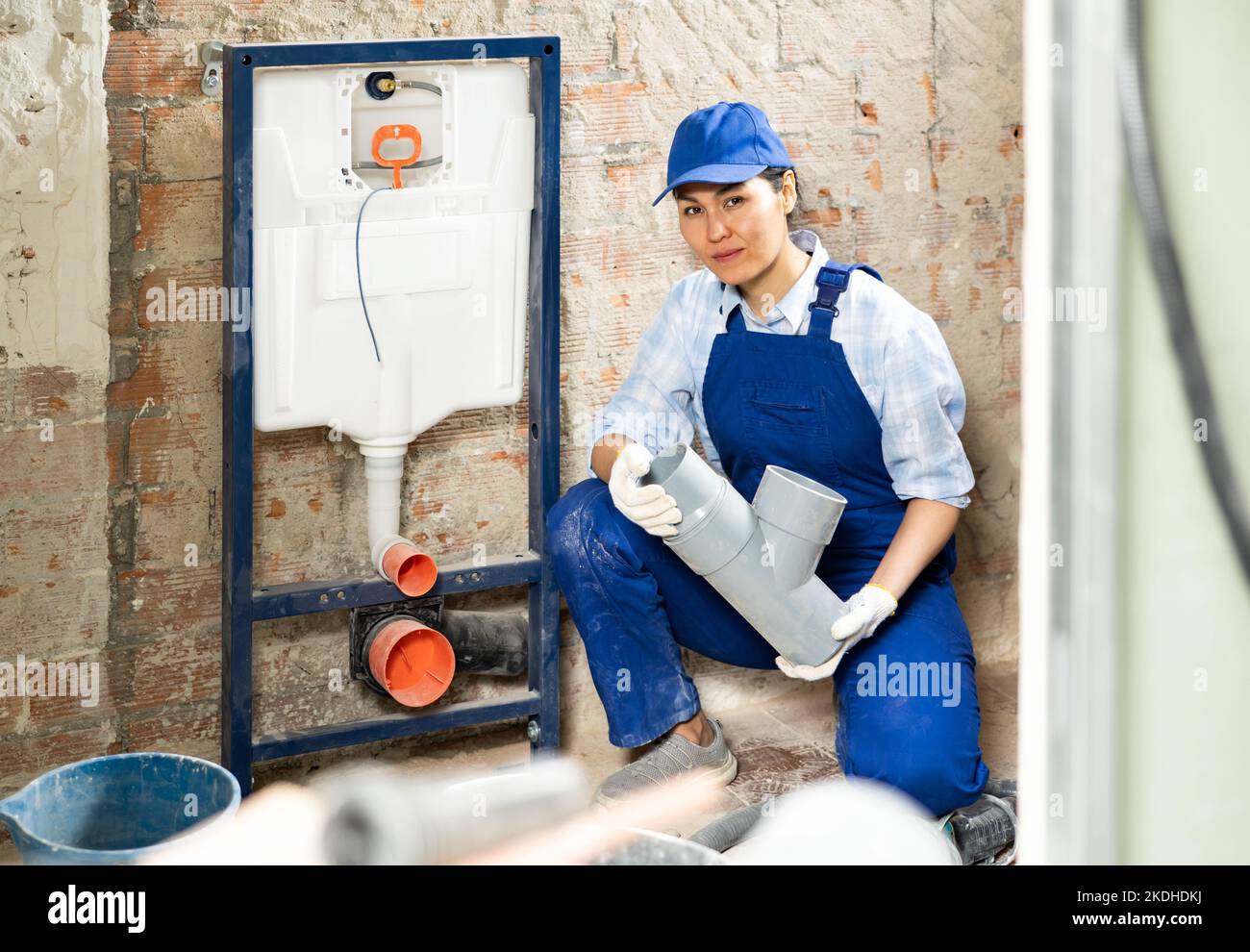 Plumber installing back to wall toilet system Stock Photo - Alamy