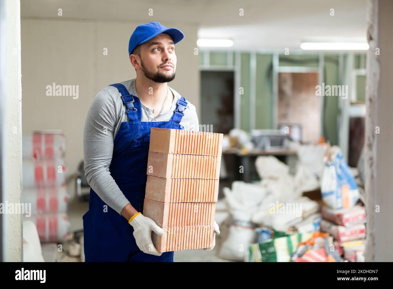 Construction worker carrying bricks at renovating object Stock Photo ...