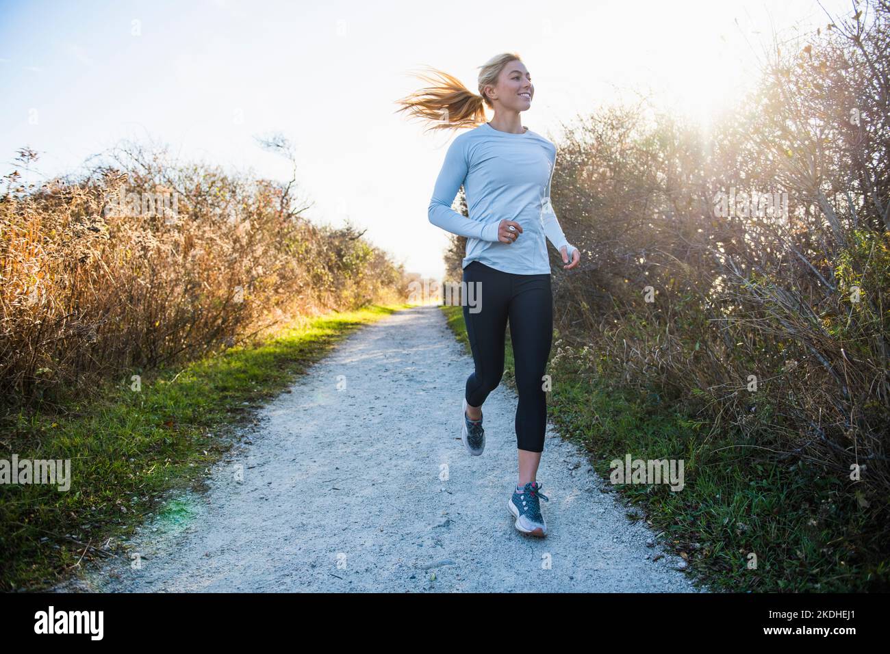 Young woman running on open air coastal trail run workout Stock Photo ...