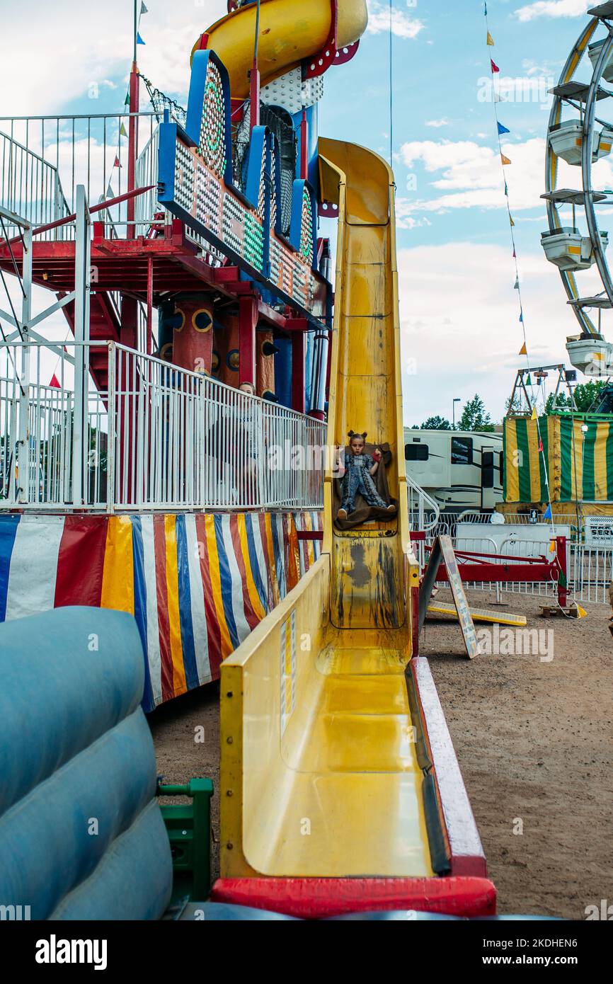 Young girl going down a large slide at a carnival Stock Photo - Alamy