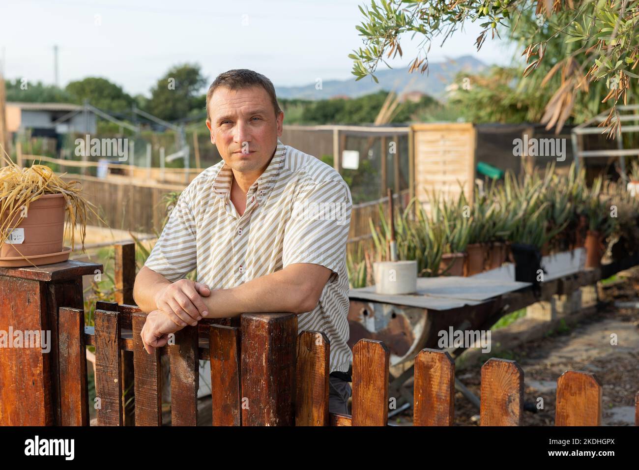 Male farmer posing at fence of his farm on summer day Stock Photo - Alamy