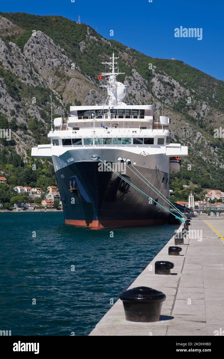 Moored Minerva cruise ship in the port of Kotor with mountain landscape ...