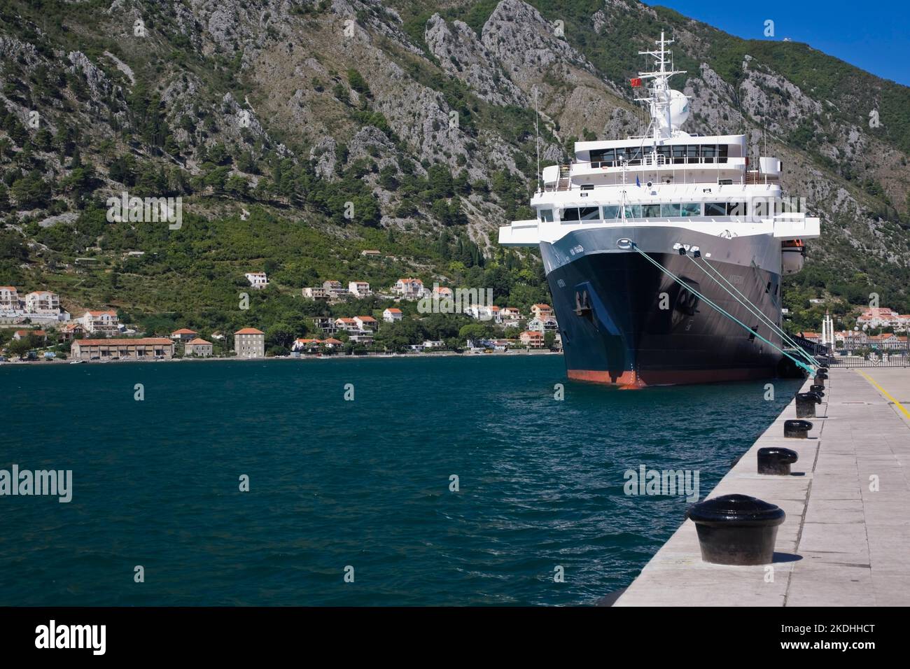 Moored Minerva cruise ship in the port of Kotor with mountain landscape ...