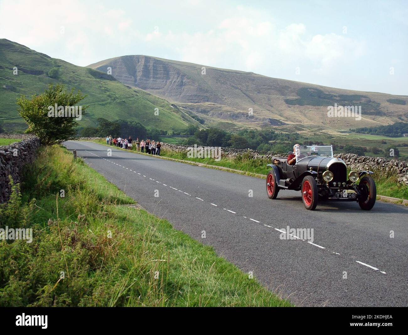 A couple drive a vintage car in Castleton in the Peak District national ...