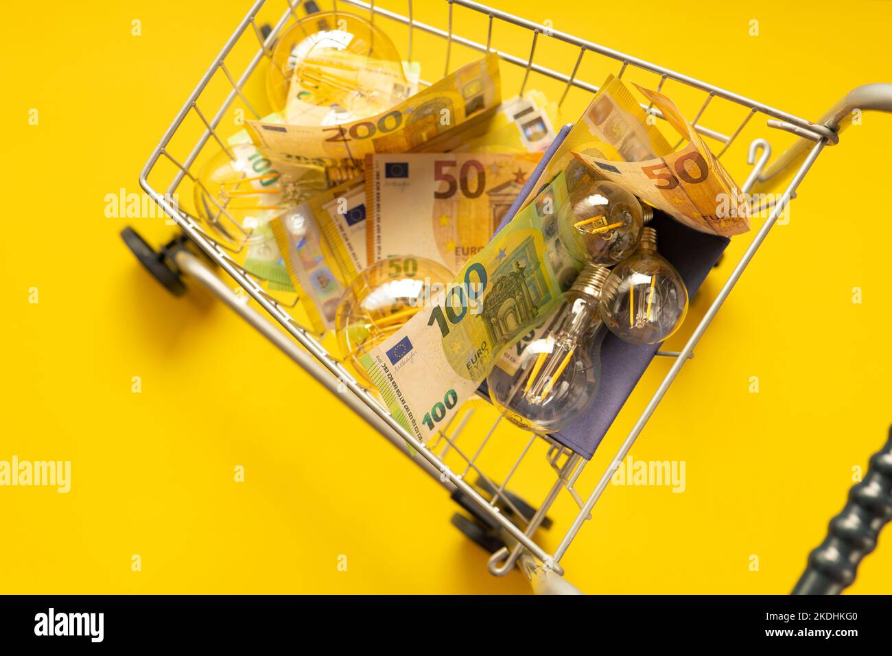 Electricity costs.Light bulbs and euro banknotes on a yellow background ...