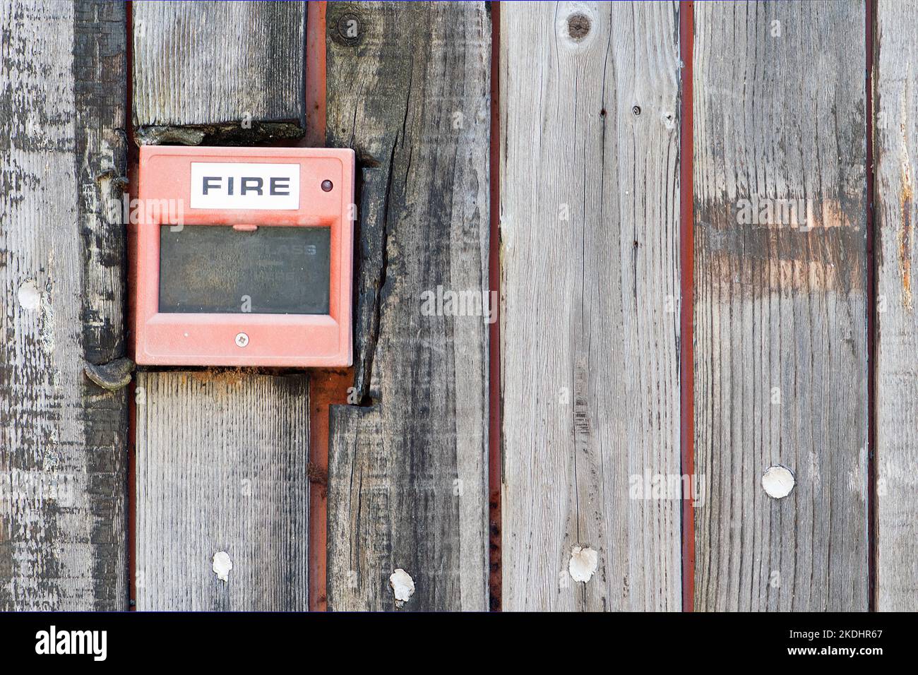 Red Fire alarm on the wooden wall background Stock Photo - Alamy