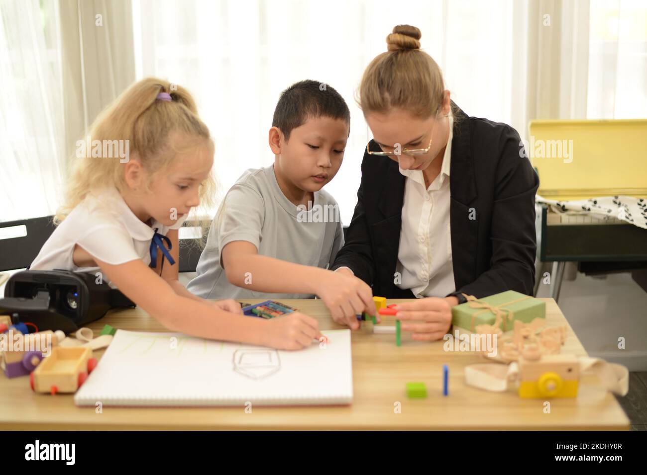 The teacher is teaching a young child to paint happily on paper. Look ...