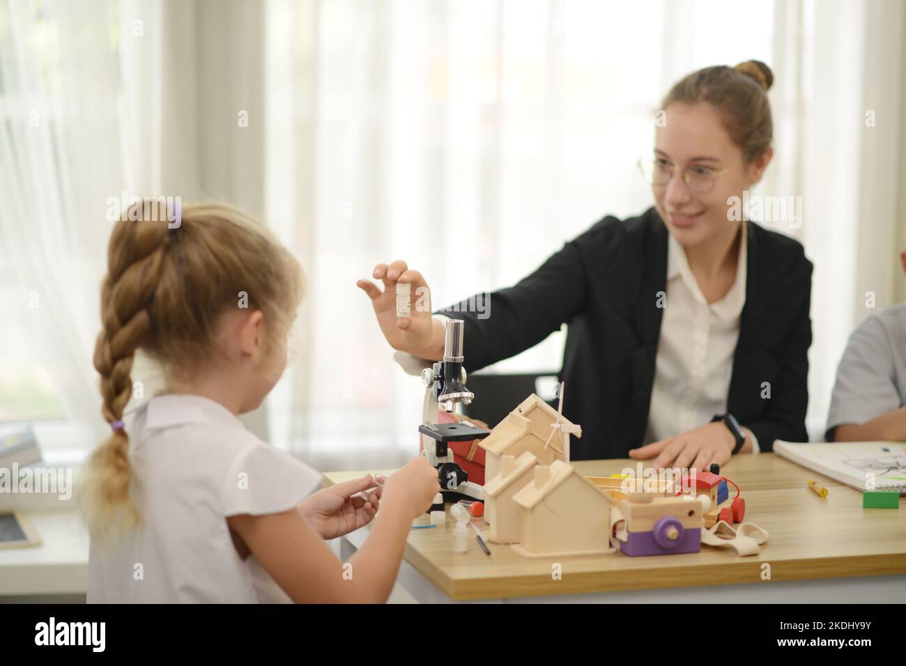 Friendly teachers help elementary school students in class Stock Photo ...