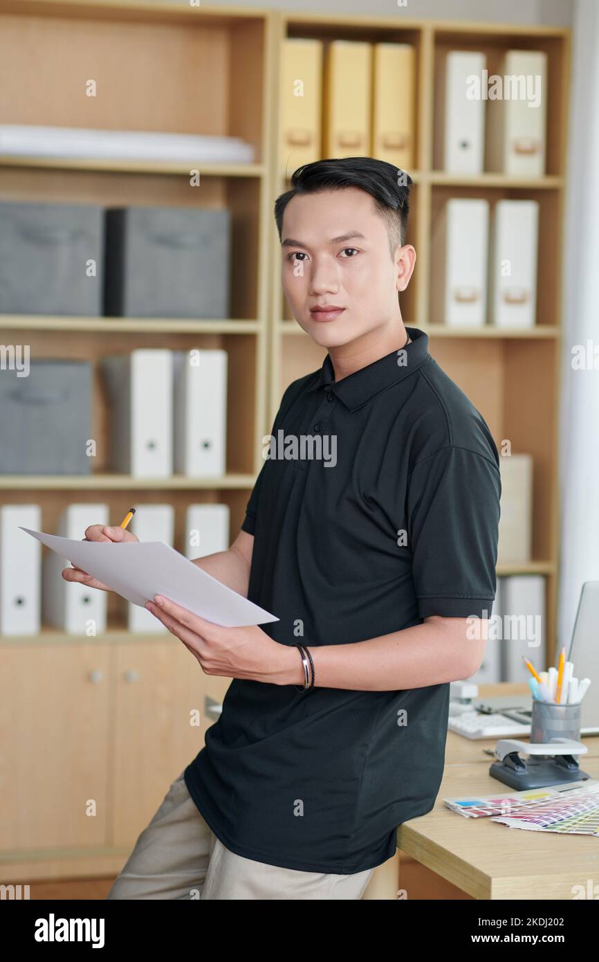 Portrait of young creative designer or architect leaning on office ...