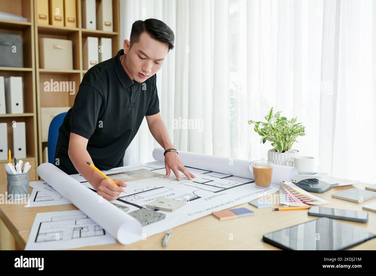 Creative interior designer working on big project for client, checking ...