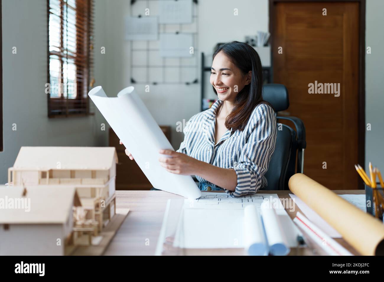 Portrait of an Asian female engineers are designing house structures and architectural using ...