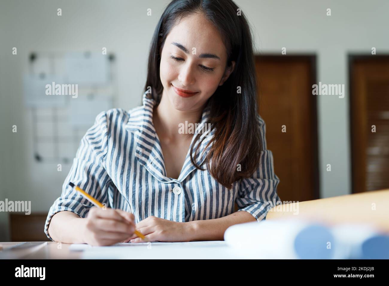 Portrait of an Asian female engineers are designing house structures ...