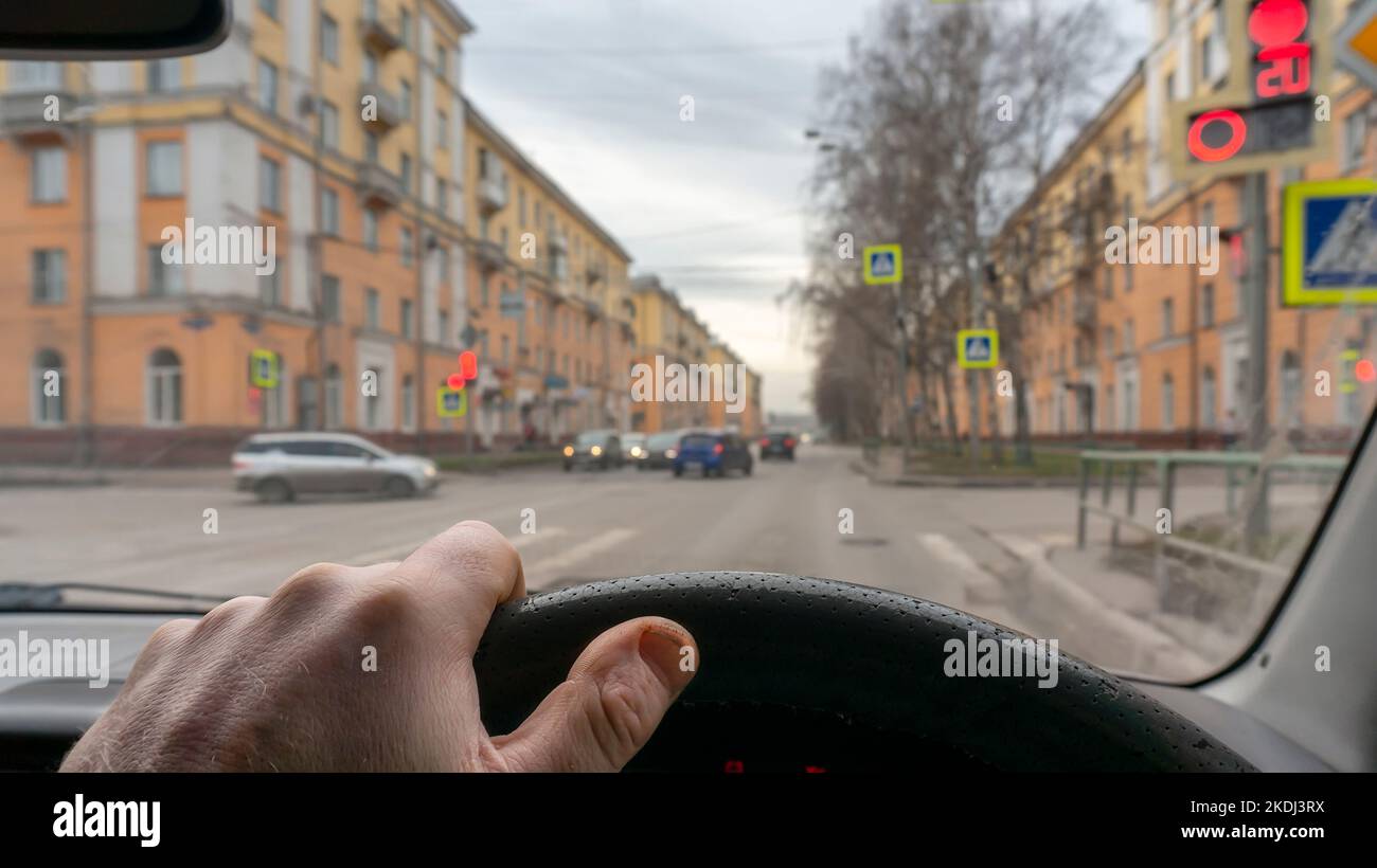 view of the driver hand inside the car, waiting for the traffic light ...