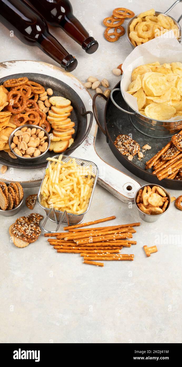 Assortment of beer and salty snacks on light background. Party food ...