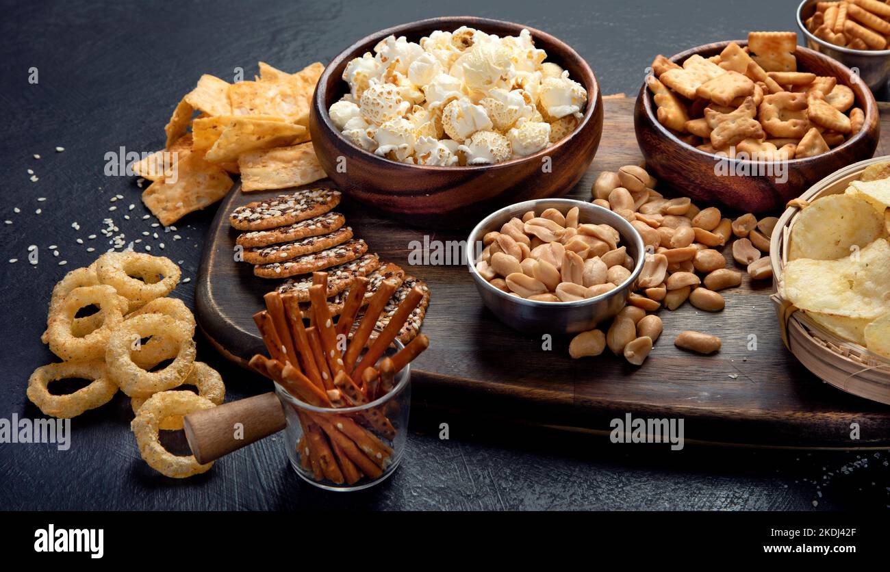 Assortment of salty snacks on dark background. Party food concept Stock ...