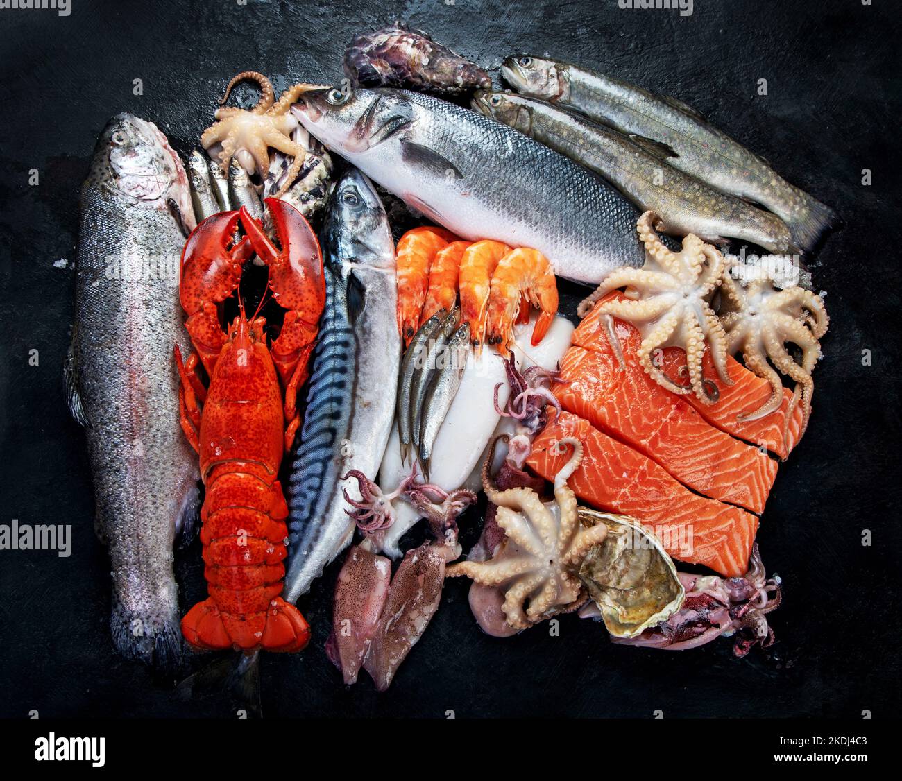 Fresh fish and seafood assortment on black background, fish market ...