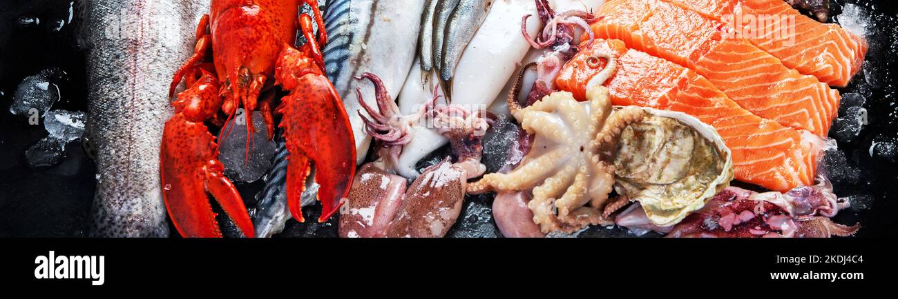 Fresh fish and seafood assortment on black background, fish market ...