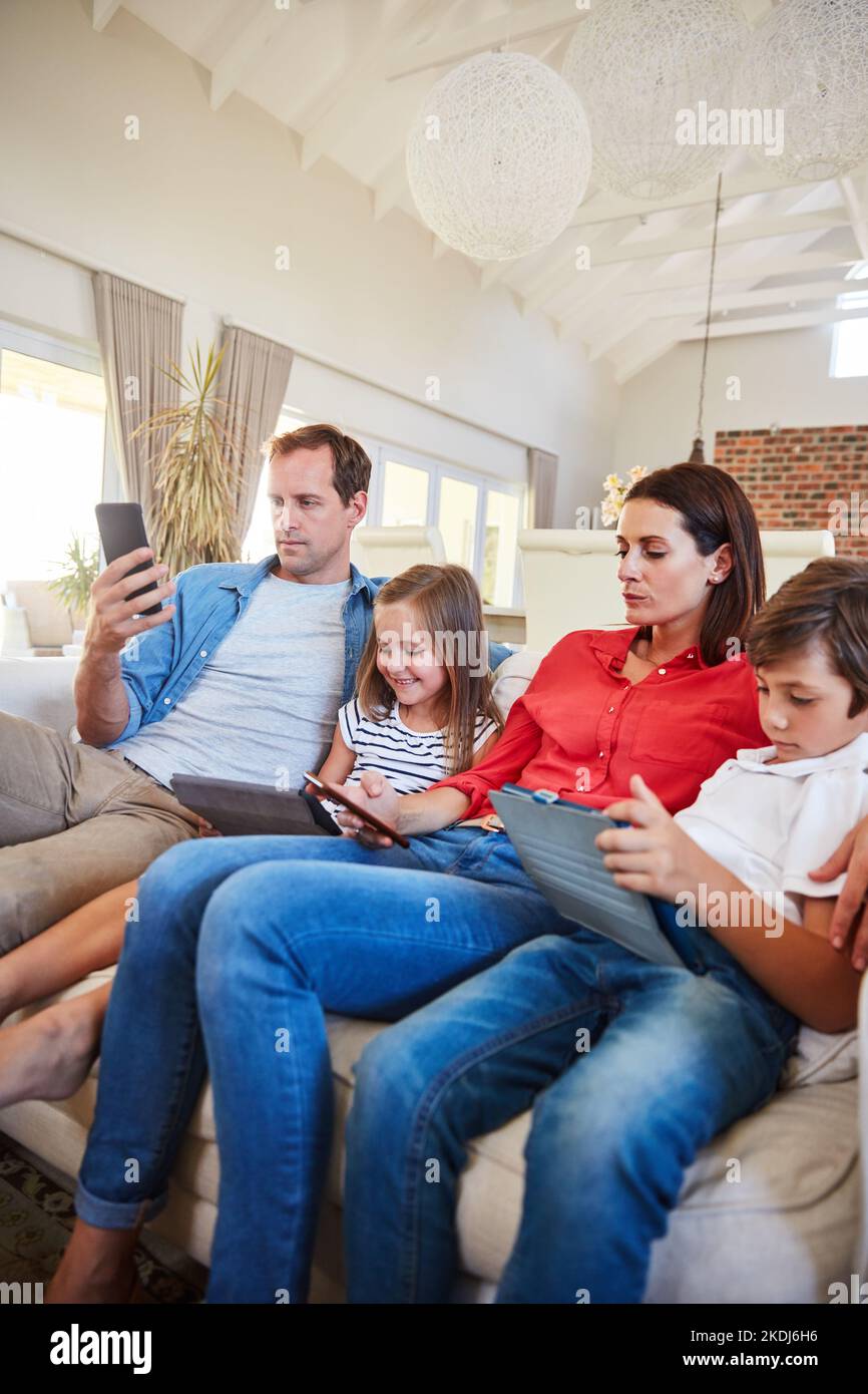 Distracted from family. a young family sitting together on their living ...