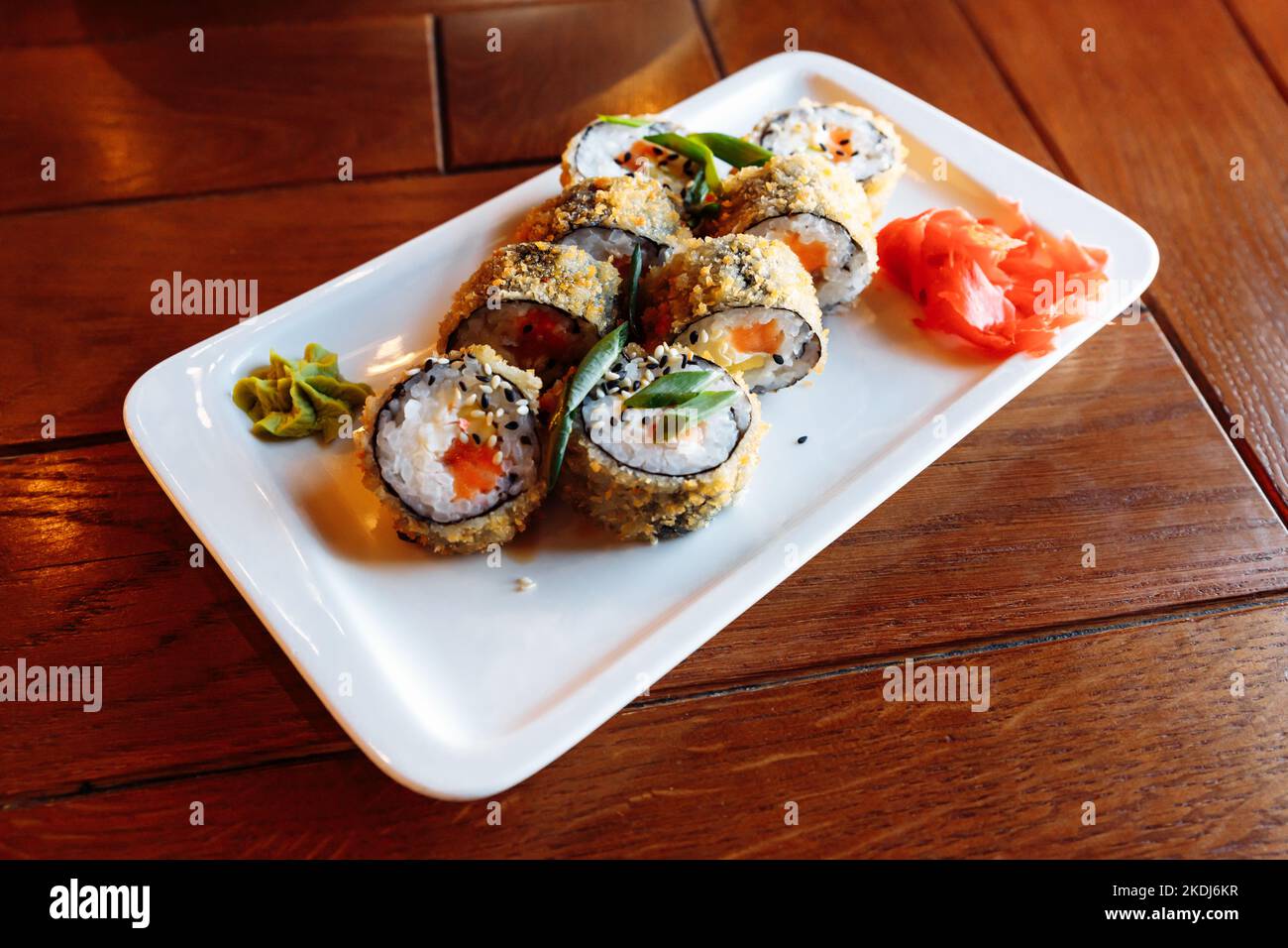 Baked Maki sushi with tempura, baked rolls on white rectangular plate ...