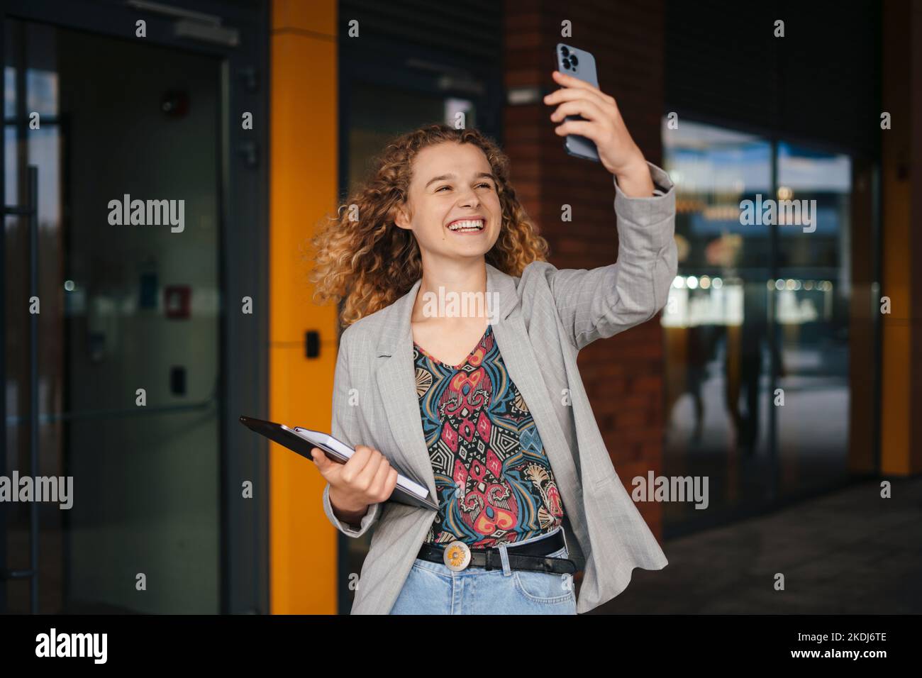 Portrait of charming positive young student woman holding laptop in her ...