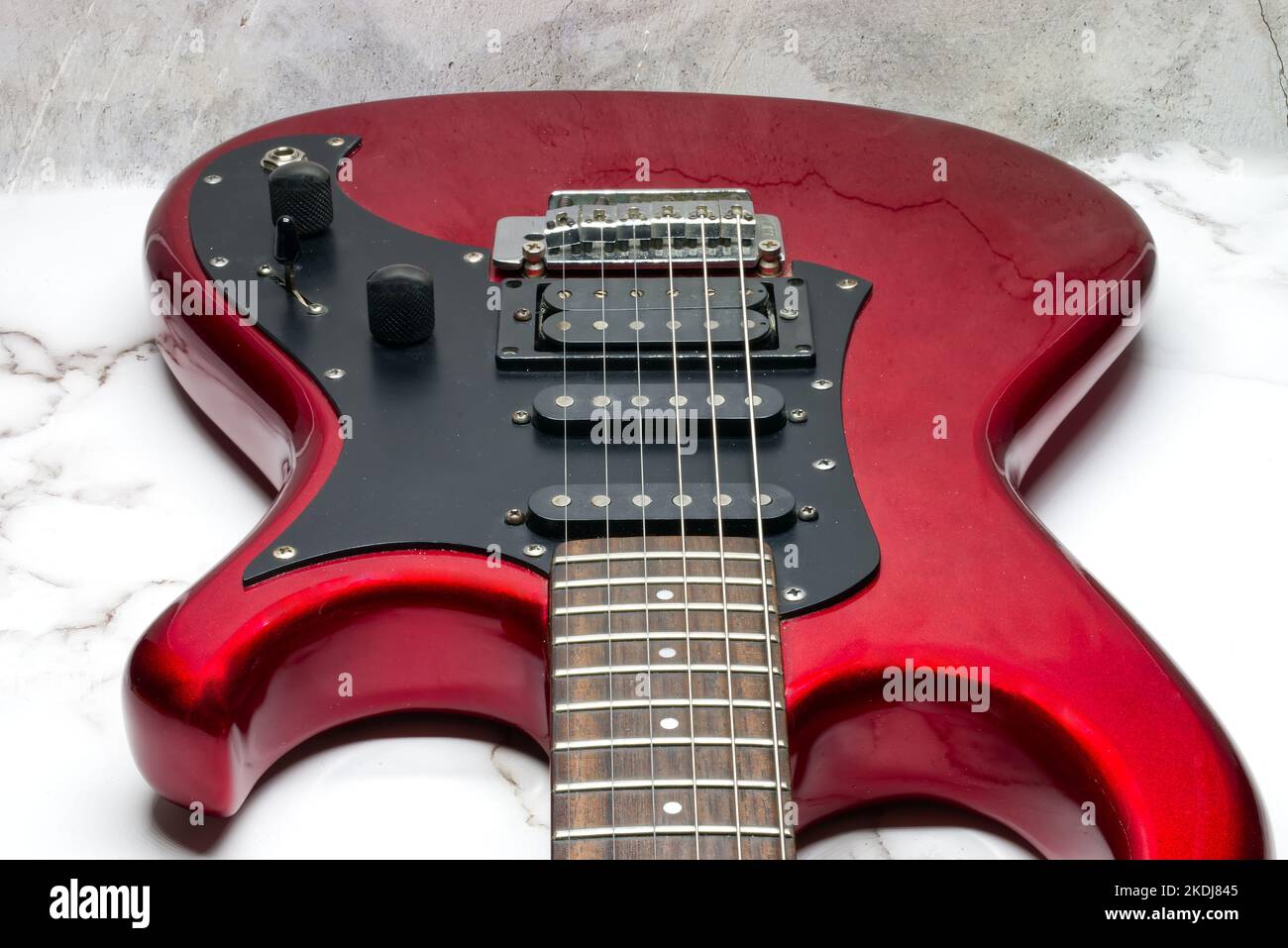 Red electric guitar isolated on marble background Stock Photo - Alamy