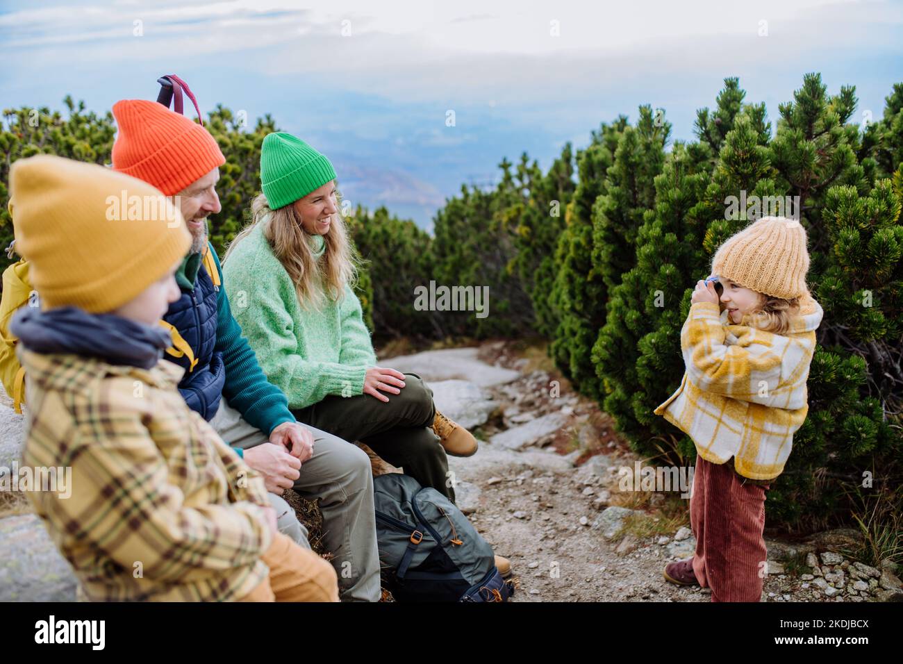 Little girl taking photos of her family, having break during hiking in ...