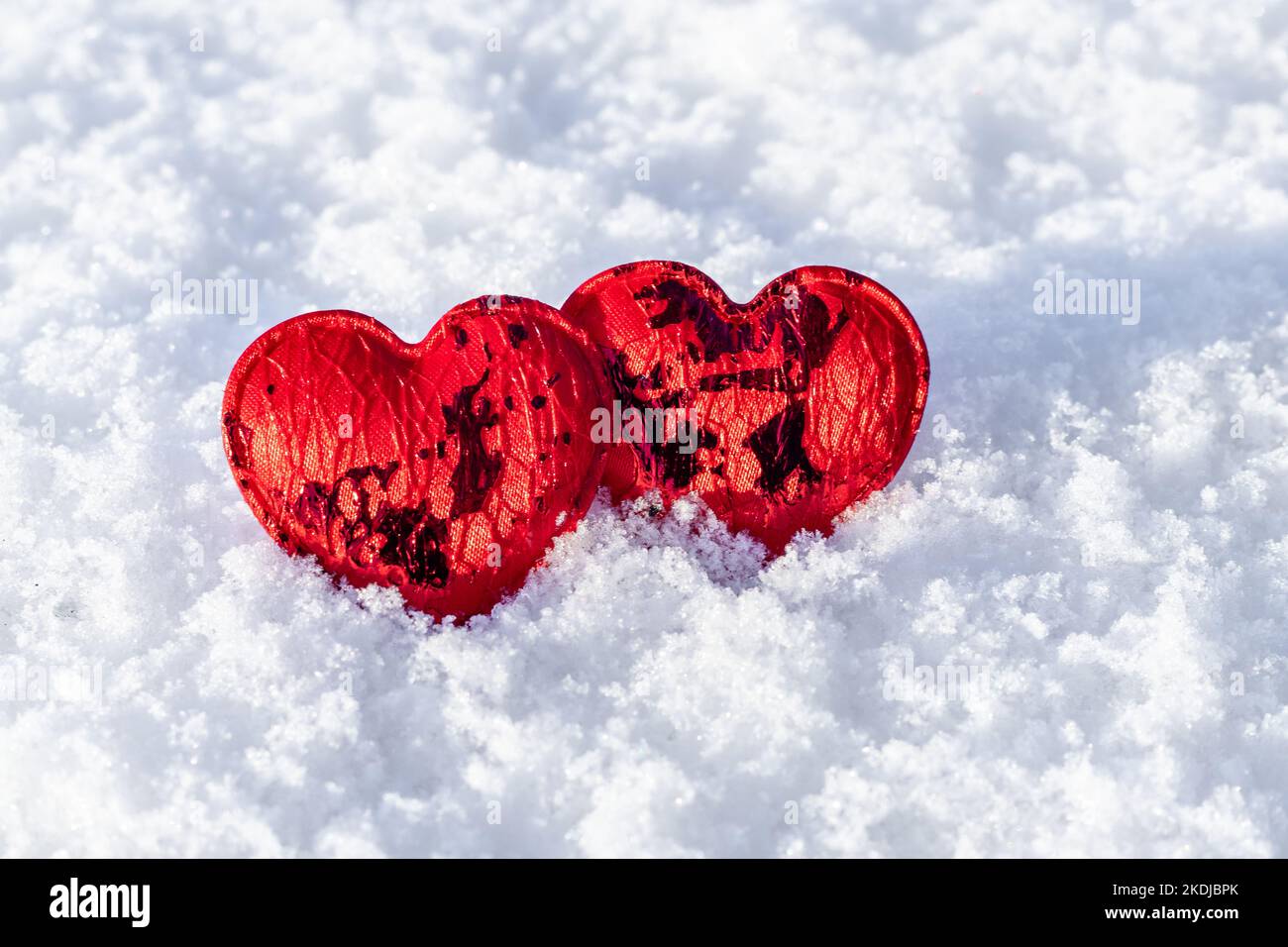 Two red hearts on a background of white snow close-up. Valentine's day ...