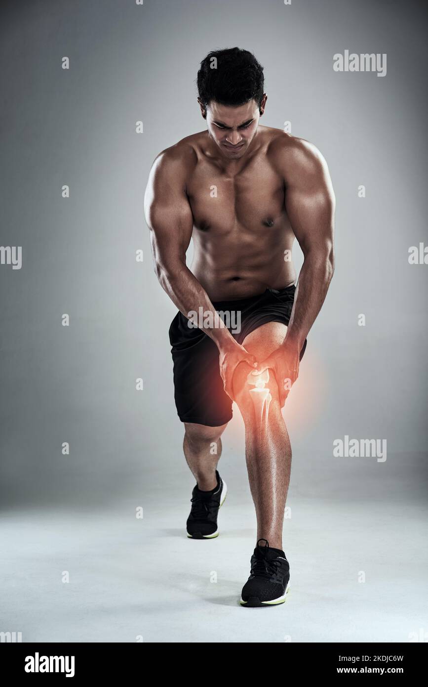 Taking a lot of pressure on his knee. Full length shot of a sporty ...