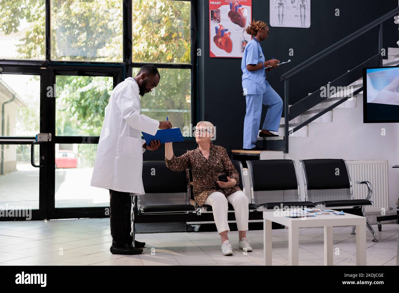 Physician doctor giving medical documents to elderly patient to sign ...