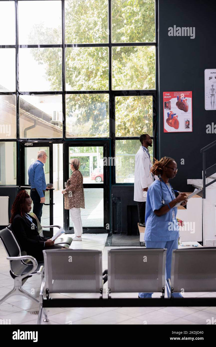 People standing in hospital waiting area during checkup visit ...