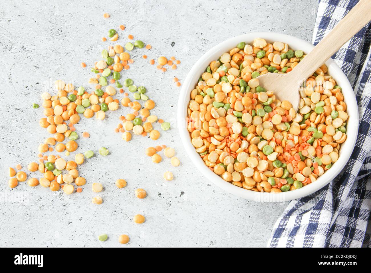 Different types of peas yellow and green in white bowl on gray stone ...