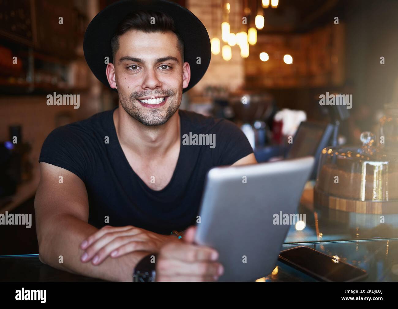 Managing a cafe is so much simpler with smart technology. a young man ...