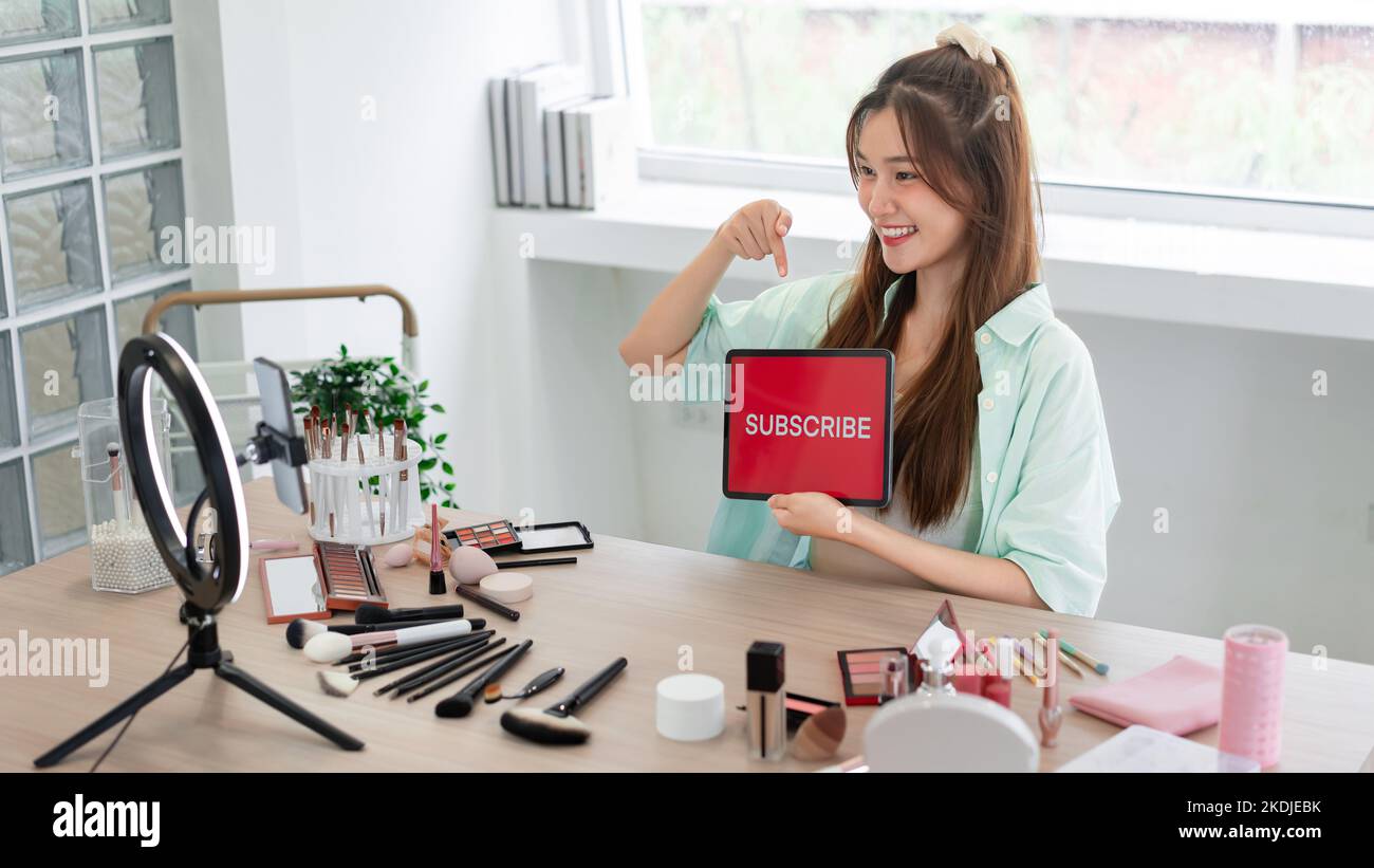 Beauty blogger concept, Young woman is pointing on subscribe text while ...