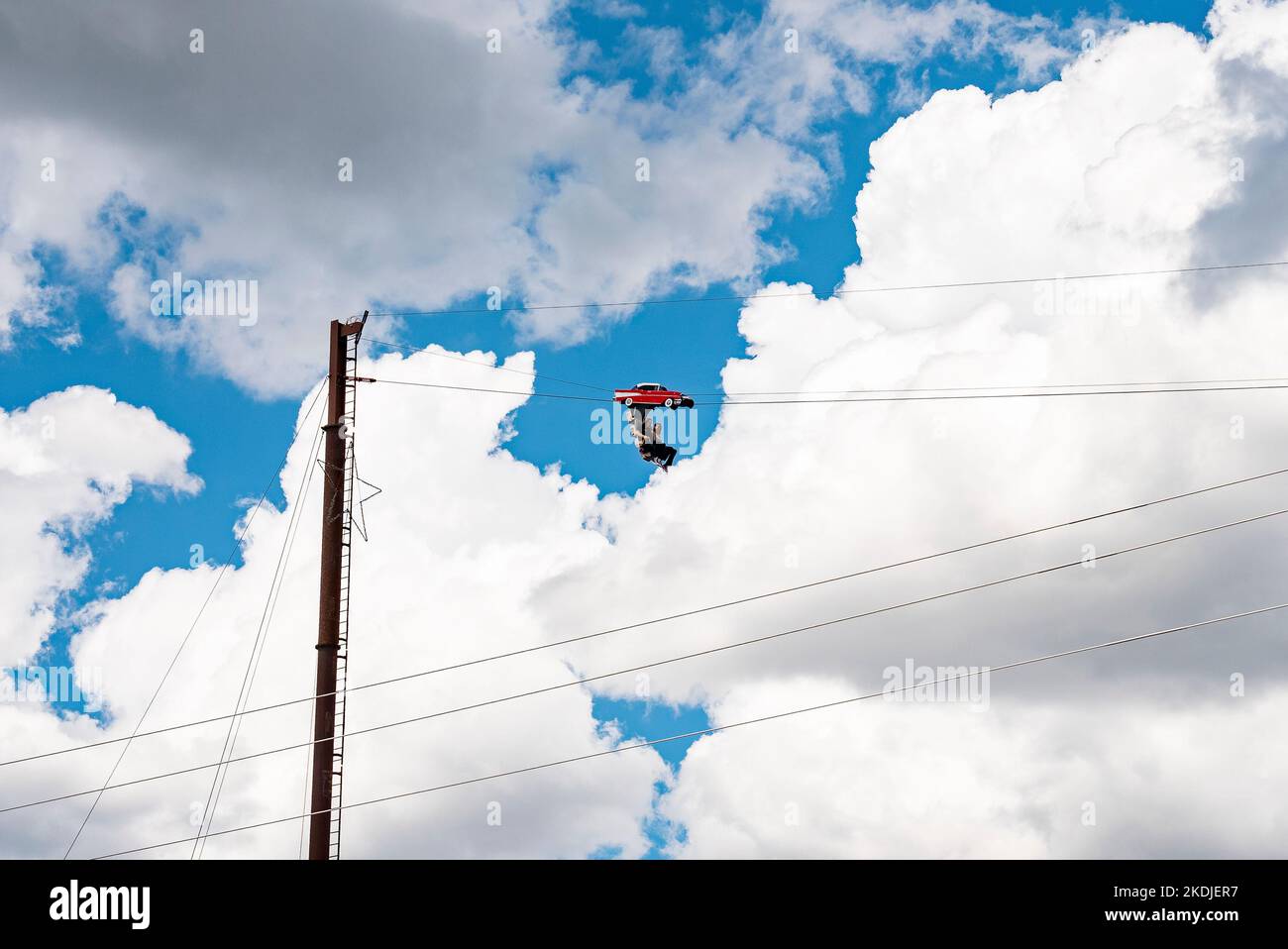 Tourists enjoying unique ride high up with cloudy sky in background ...