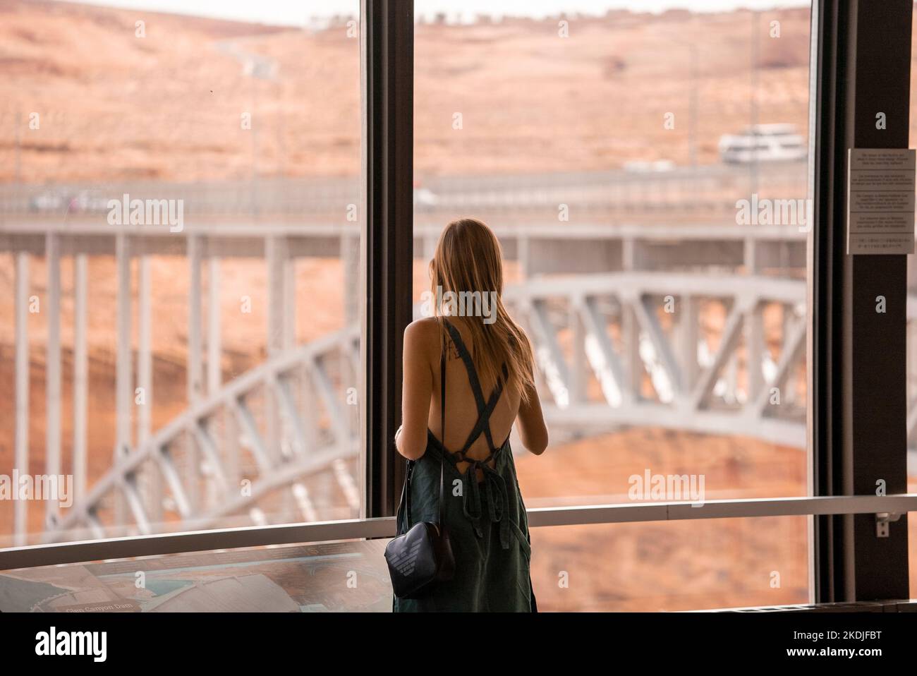 Woman Looking At Glen Canyon Dam Through glass Window Stock Photo - Alamy