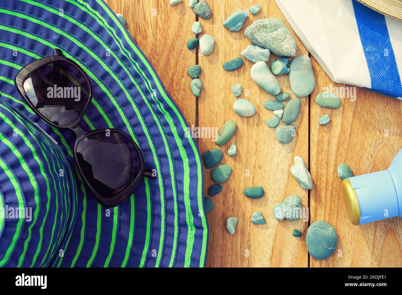 Toned image with big blue hat and pebbles and cream on the wooden ...