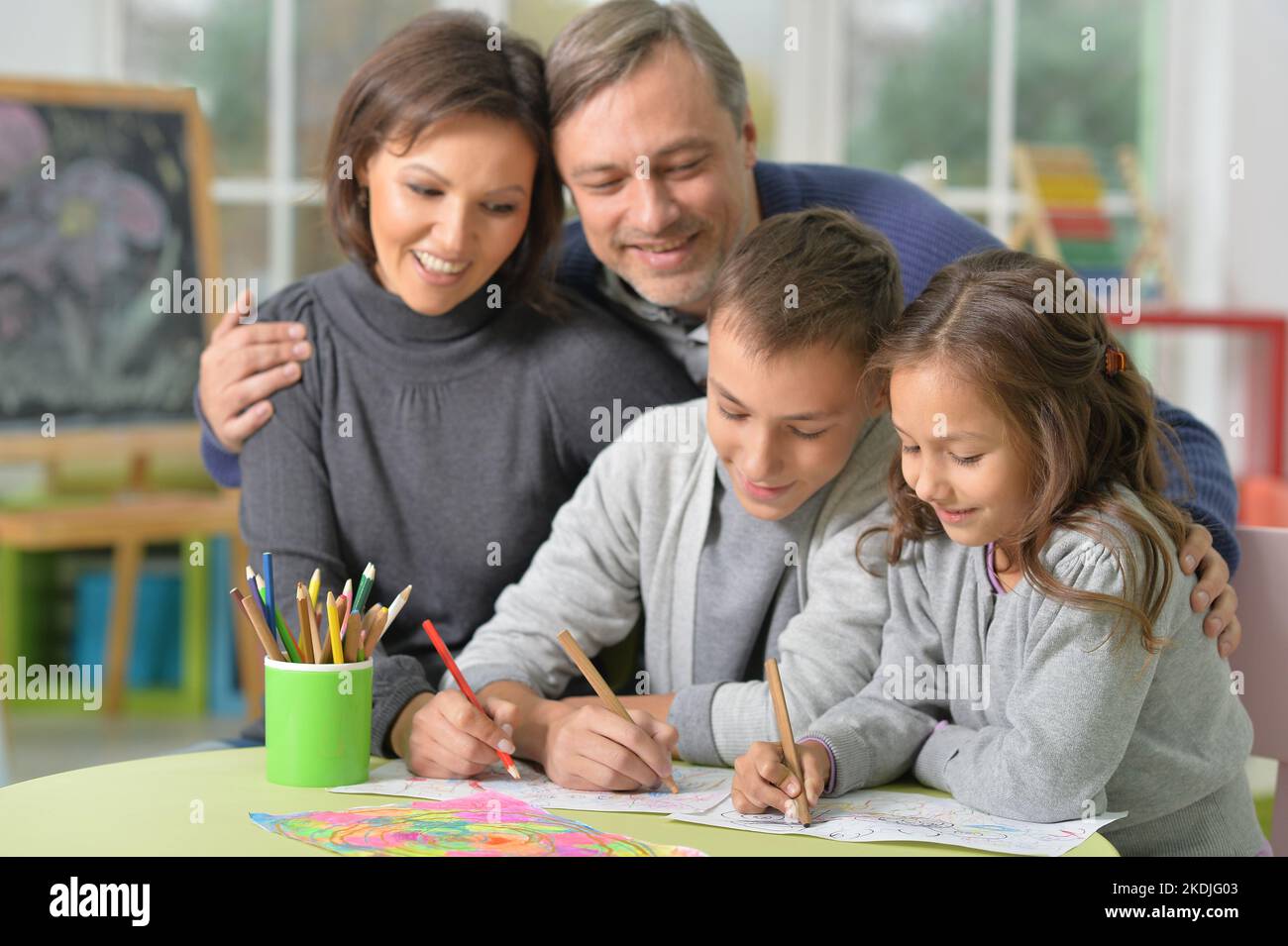 Portrait of parent and children drawing together Stock Photo - Alamy