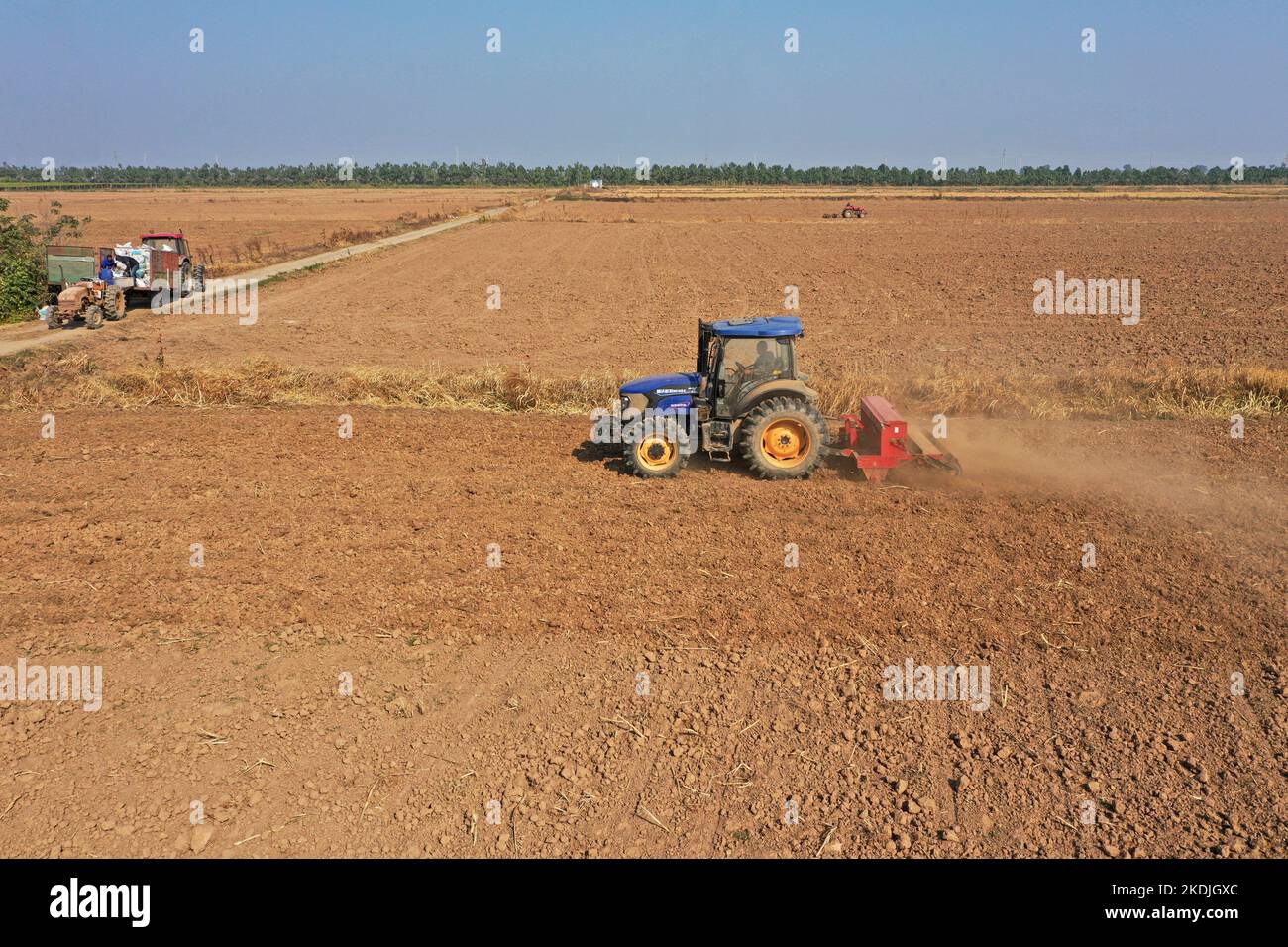 Aerial photos show workers driving rotary tillage planters to plant ...