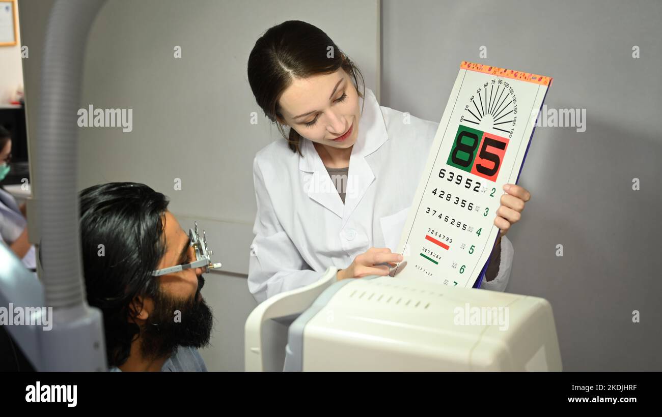 Ophthalmologist testing eyesight of male patient with eye chart at ...
