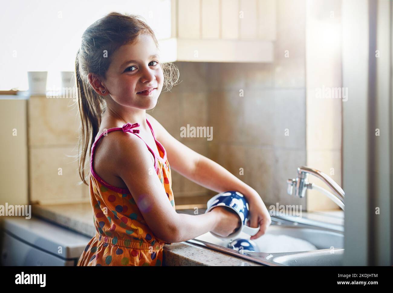 These will all be clean in no time. Portrait of a little girl washing ...